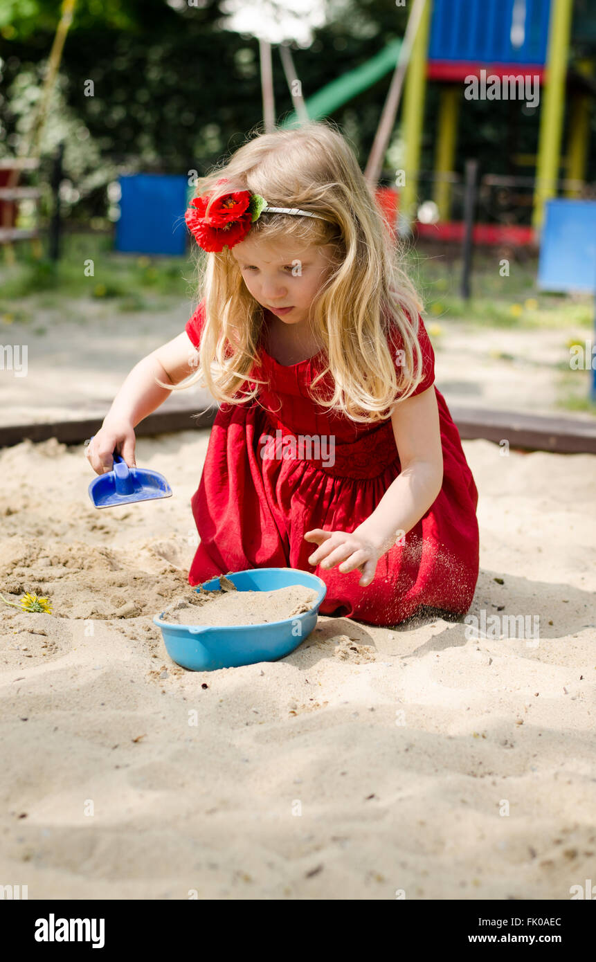 beautiful blond girl playing in sandpit Stock Photo - Alamy