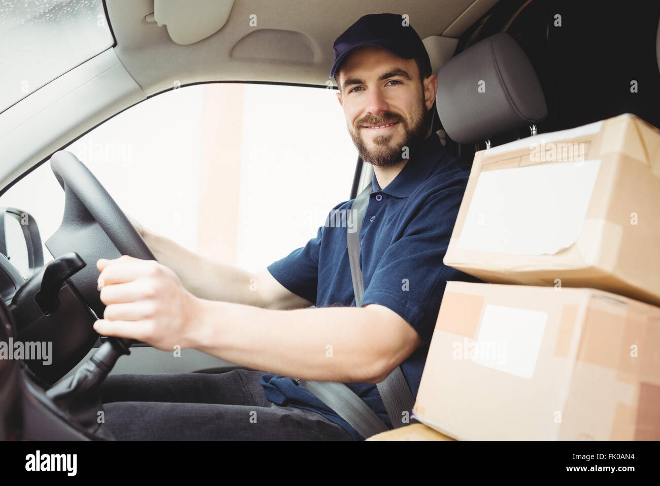 Delivery man driving his van Stock Photo - Alamy