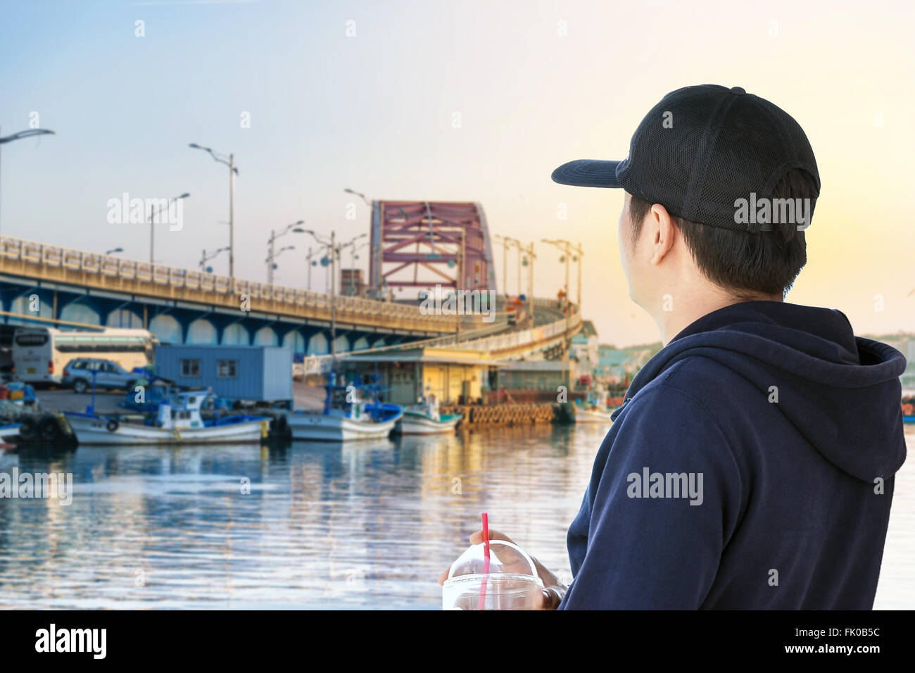 Back view of young man wearing a black cap and long sleeve blue looking ...