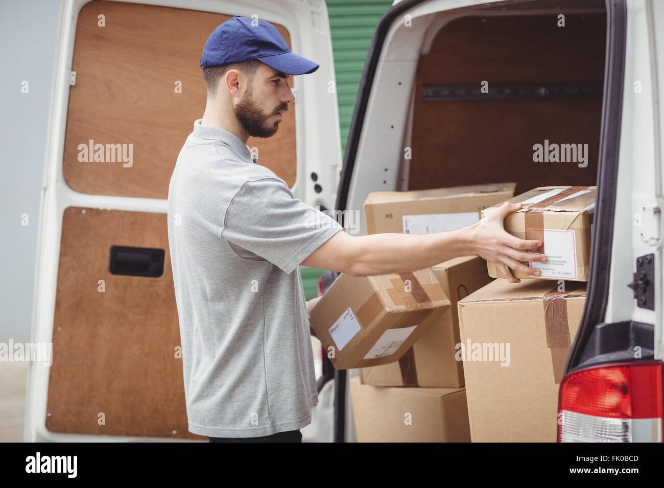 Delivery man holding packages Stock Photo - Alamy