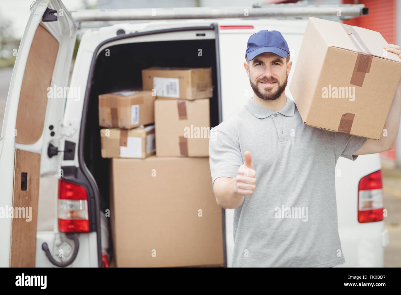 Delivery man holding package Stock Photo - Alamy
