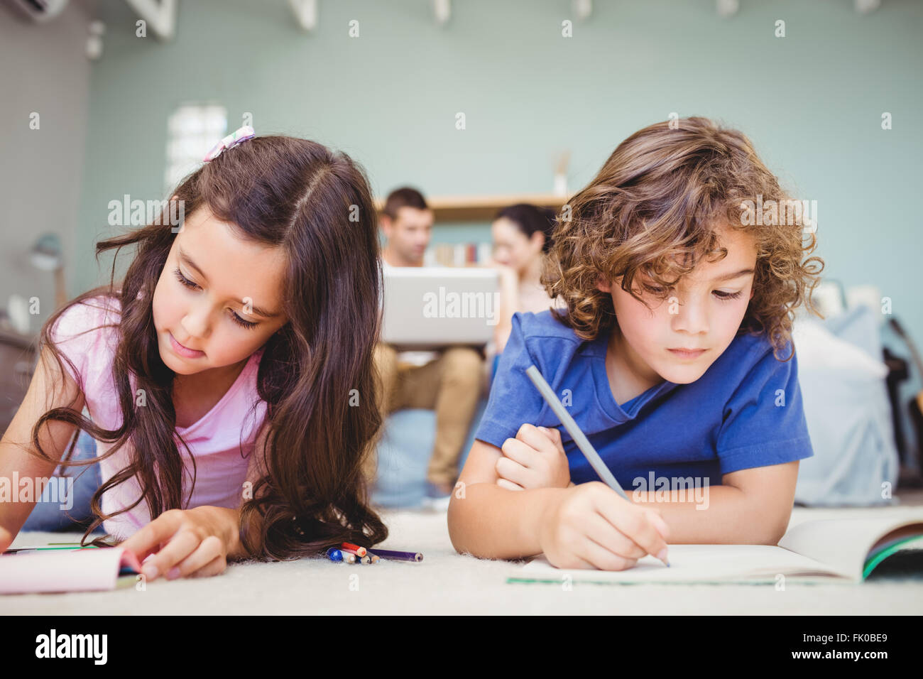Children studying while parents in background Stock Photo - Alamy