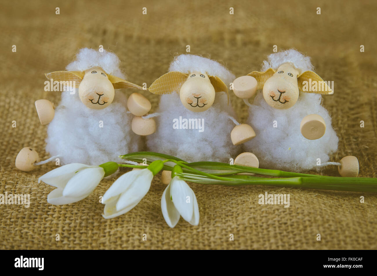 white happy smiling Easter sheep toy and snowdrop flower sitting ...