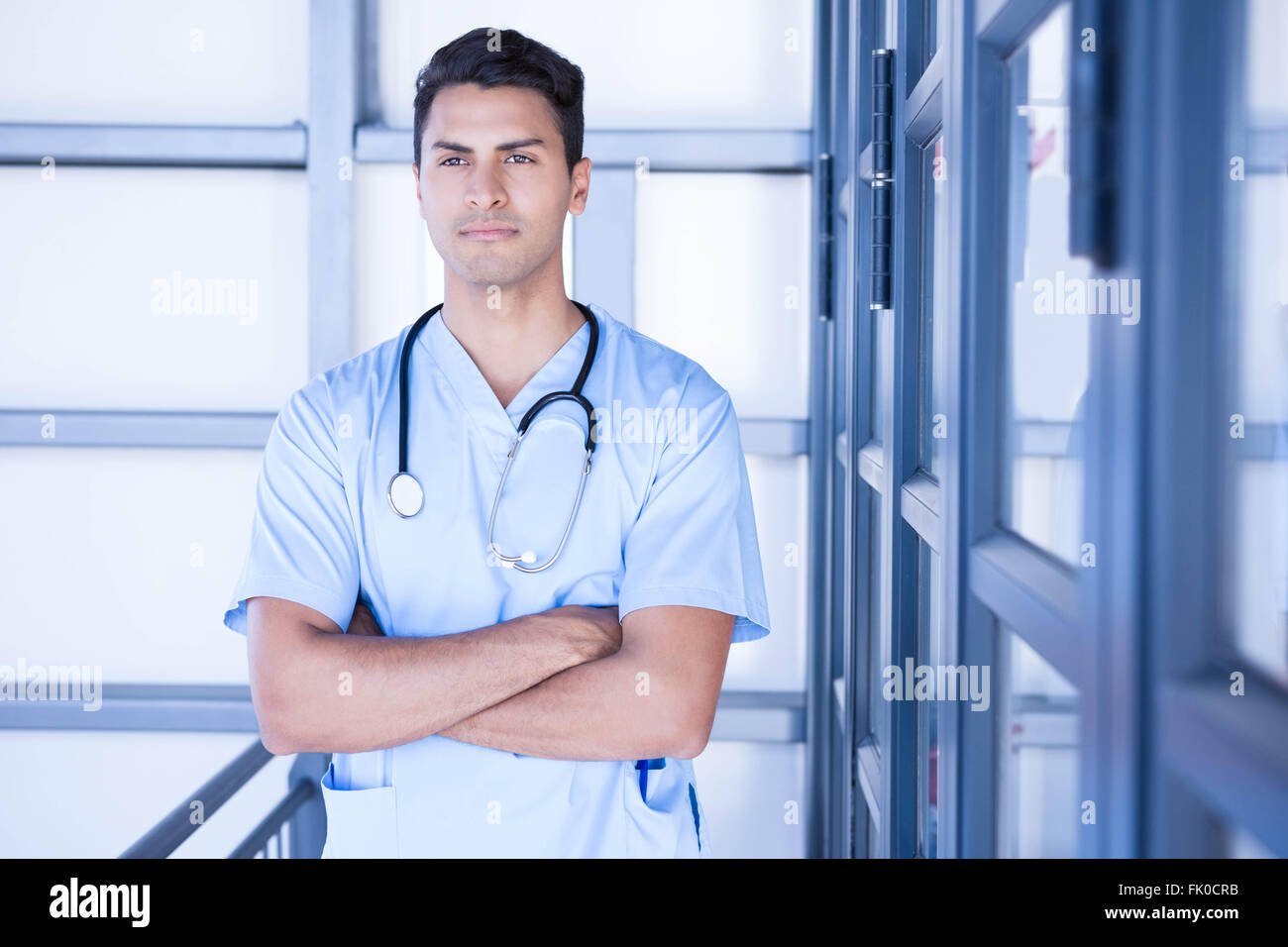 Serious male doctor standing with arms crossed Stock Photo - Alamy