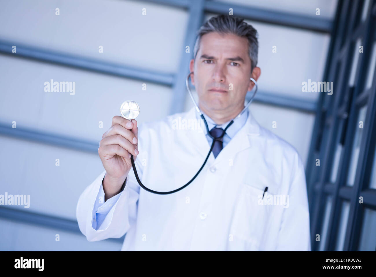 Portrait of male doctor showing stethoscope Stock Photo - Alamy