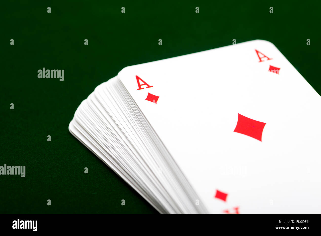 Deck of cards with ace of diamond card in top on green background Stock ...