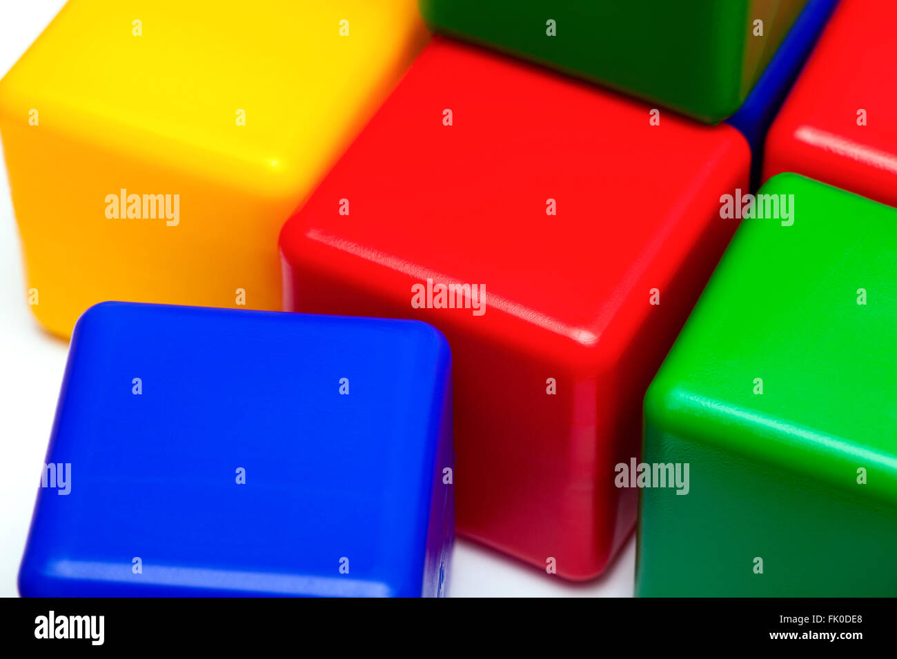 Red, blue, yellow and green plastic blocks on white background Stock ...