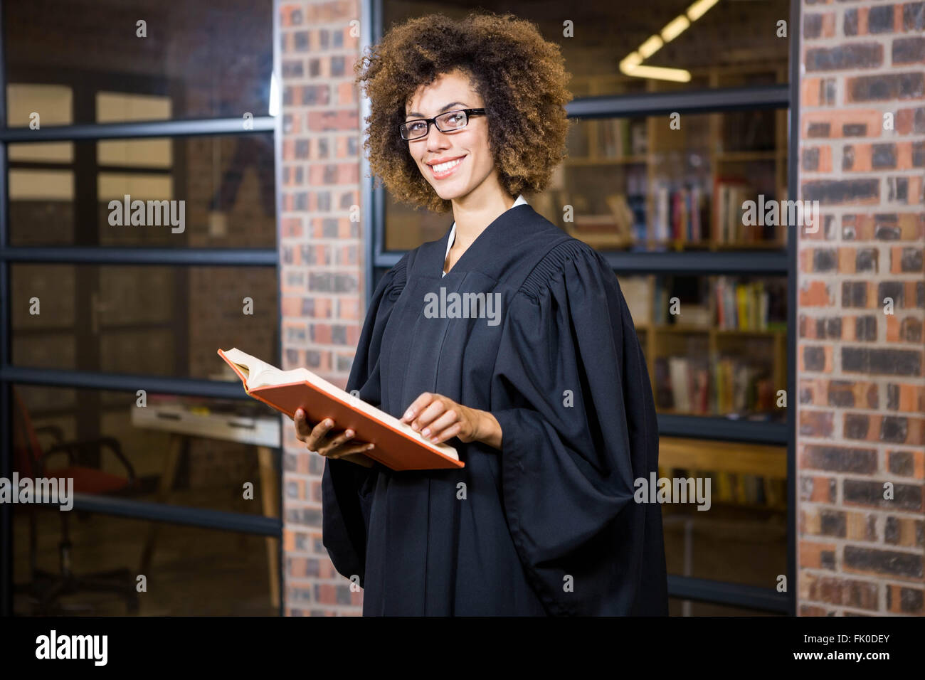 Lawyer standing near library with law book Stock Photo - Alamy