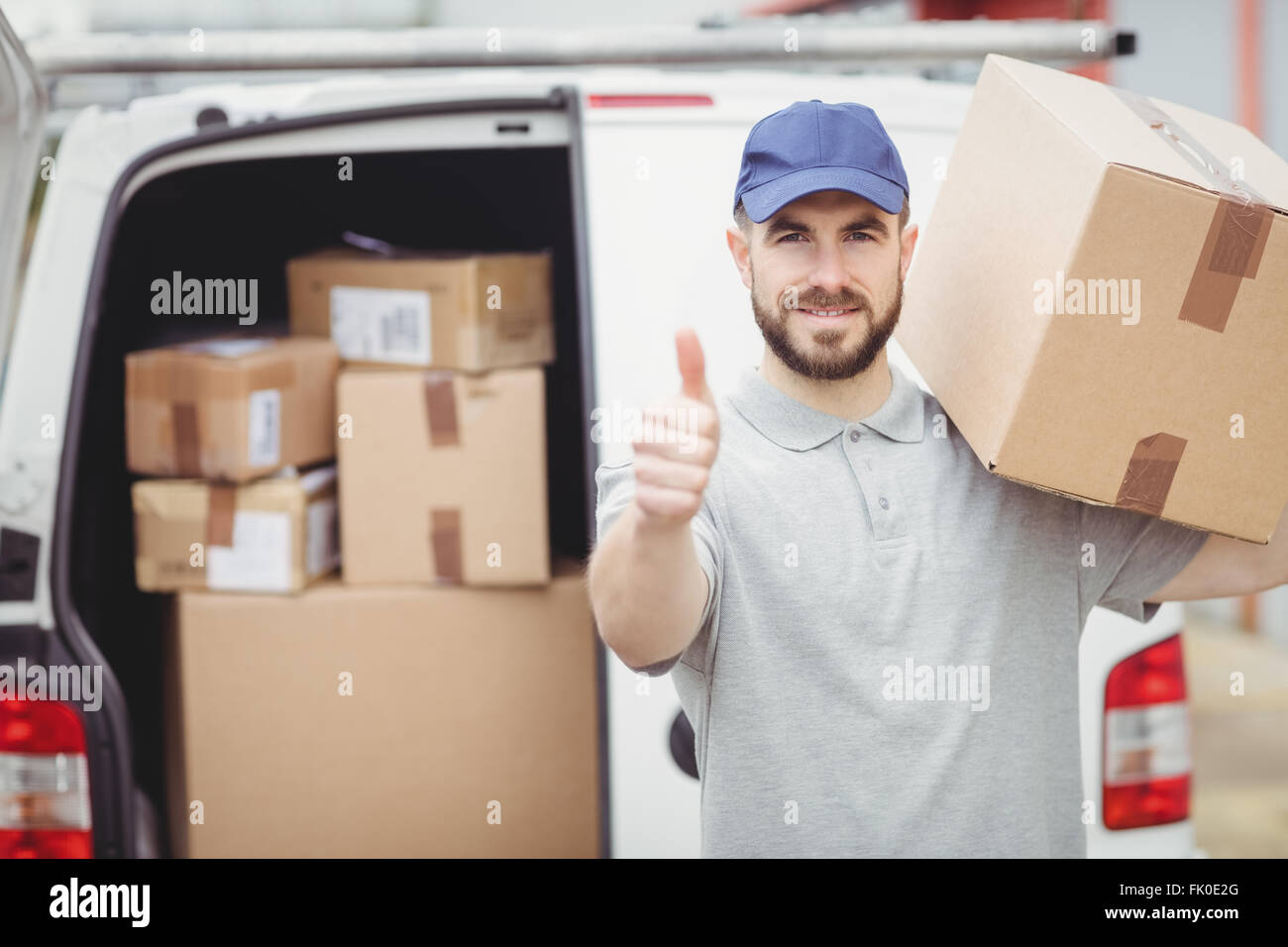 Delivery man holding package Stock Photo - Alamy