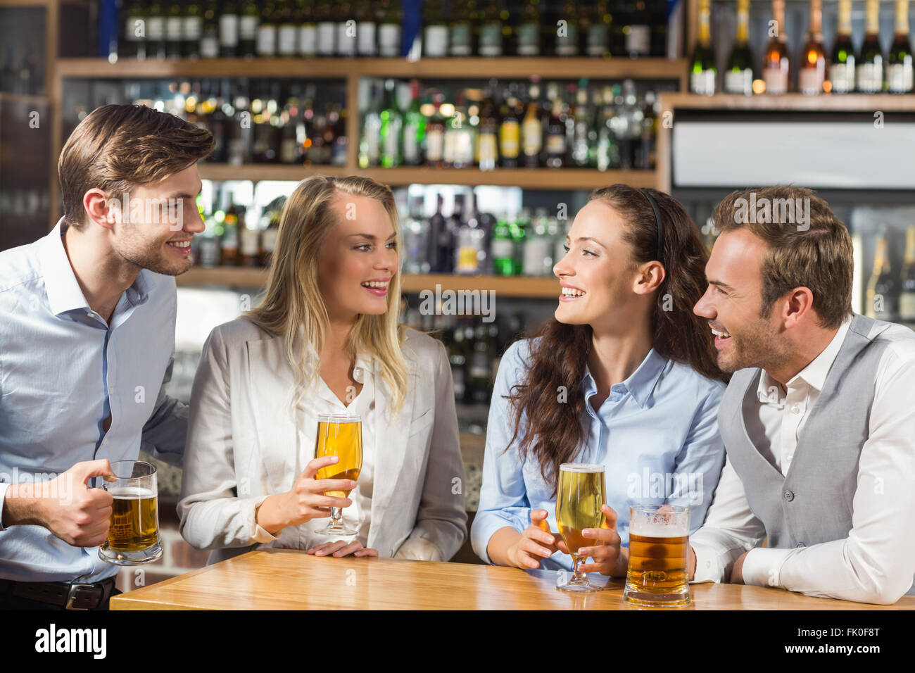 Friends talking while holding beer Stock Photo - Alamy