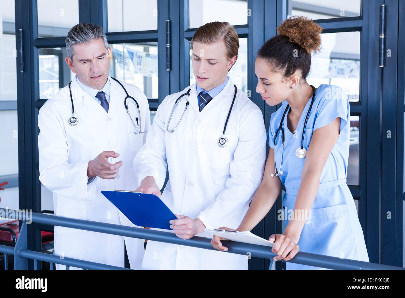Doctors discussing medical report in corridor Stock Photo - Alamy