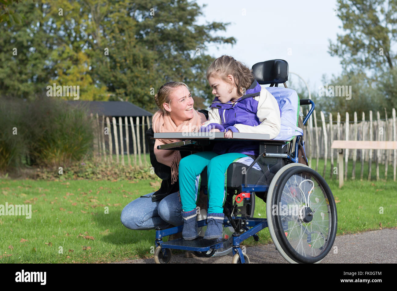 A disabled child in a wheelchair being cared for by a voluntary care ...