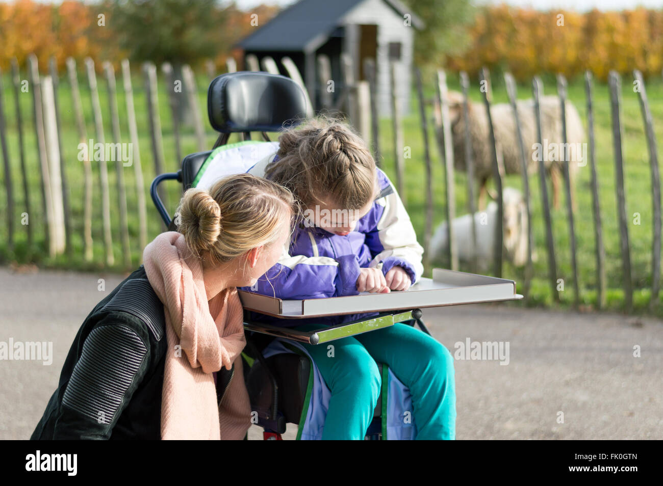A disabled child in a wheelchair being cared for by a voluntary care ...