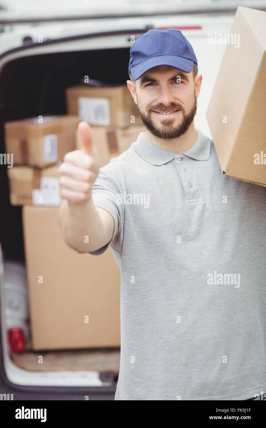 Delivery man holding package Stock Photo - Alamy