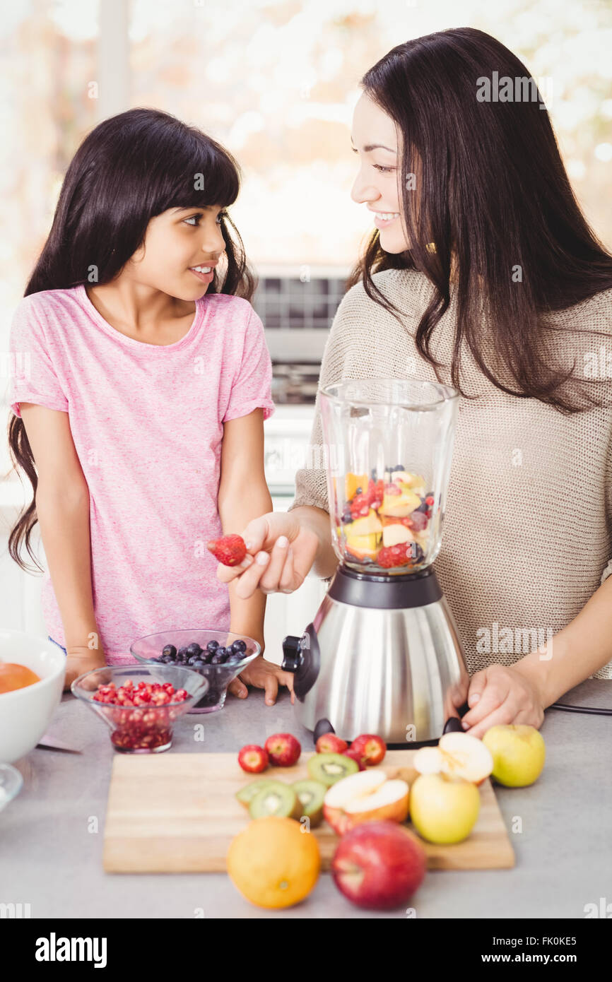 Cheerful mother and daughter preparing fruit juice Stock Photo - Alamy