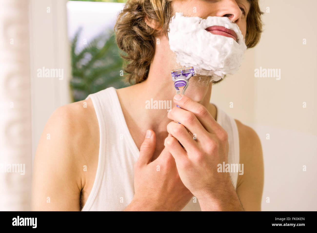 Handsome man shaving in the bathroom Stock Photo - Alamy