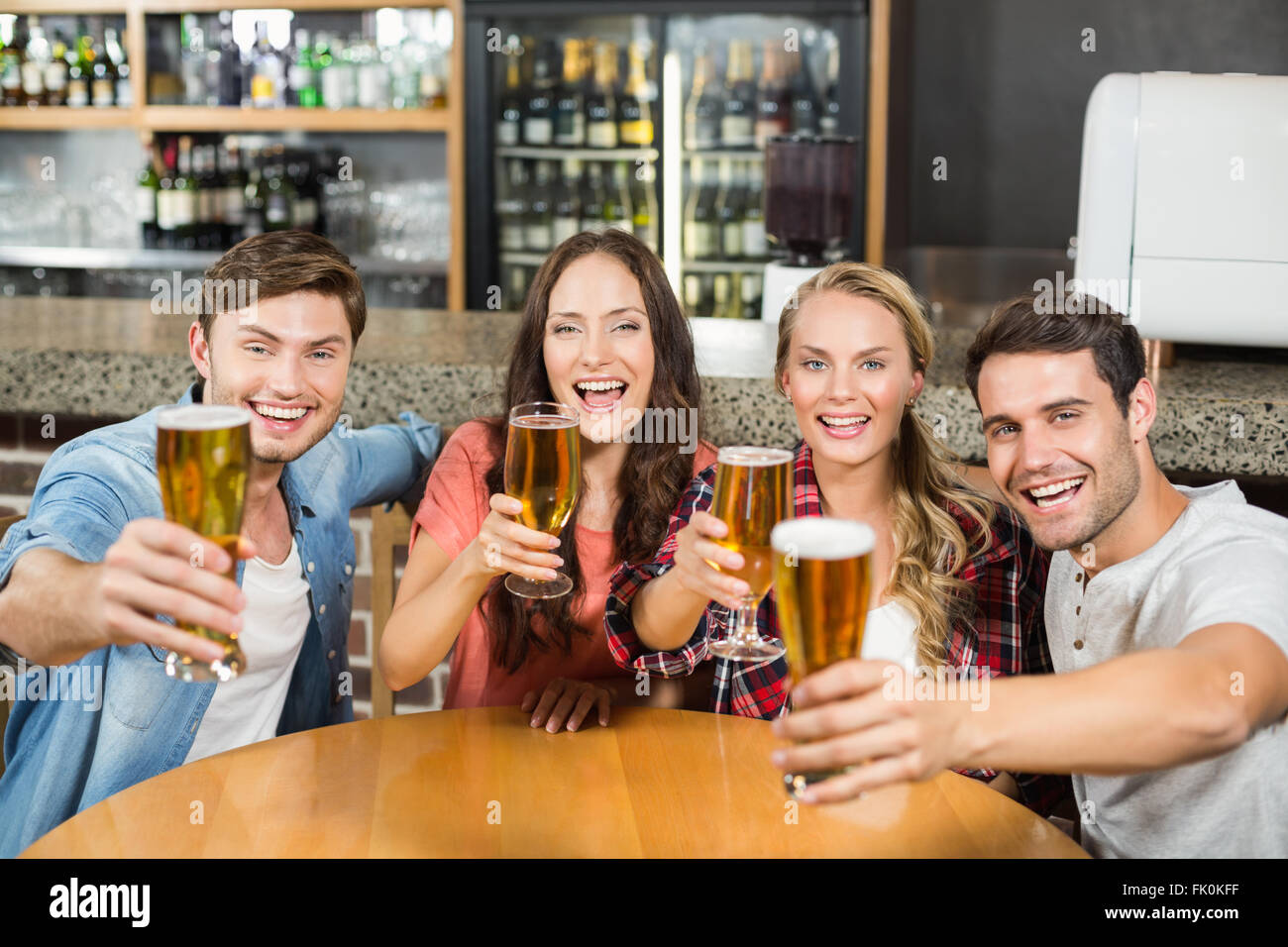 Friends interacting having beer counter hi-res stock photography and ...