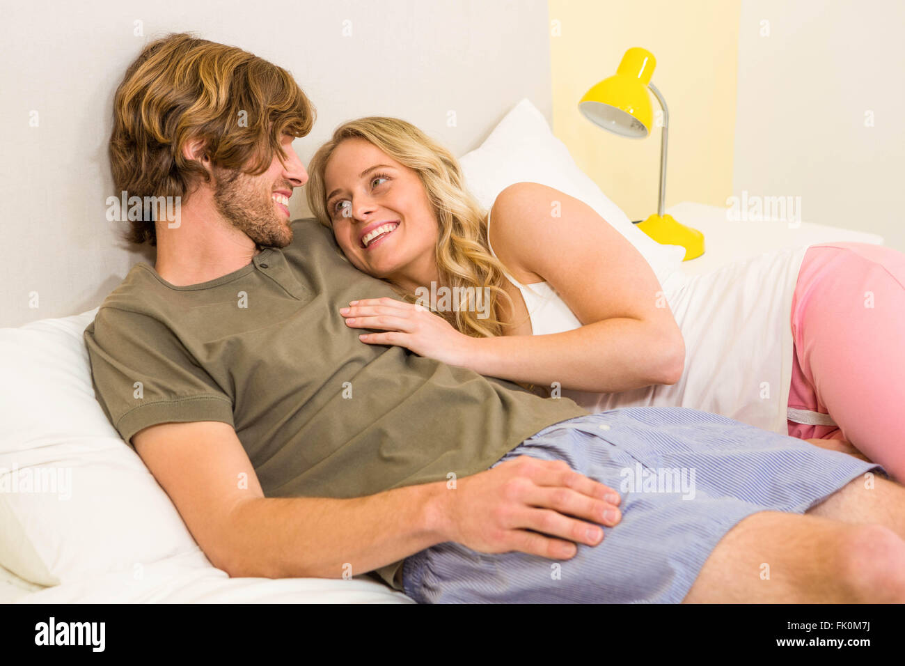Cute couple cuddling on their bed Stock Photo - Alamy