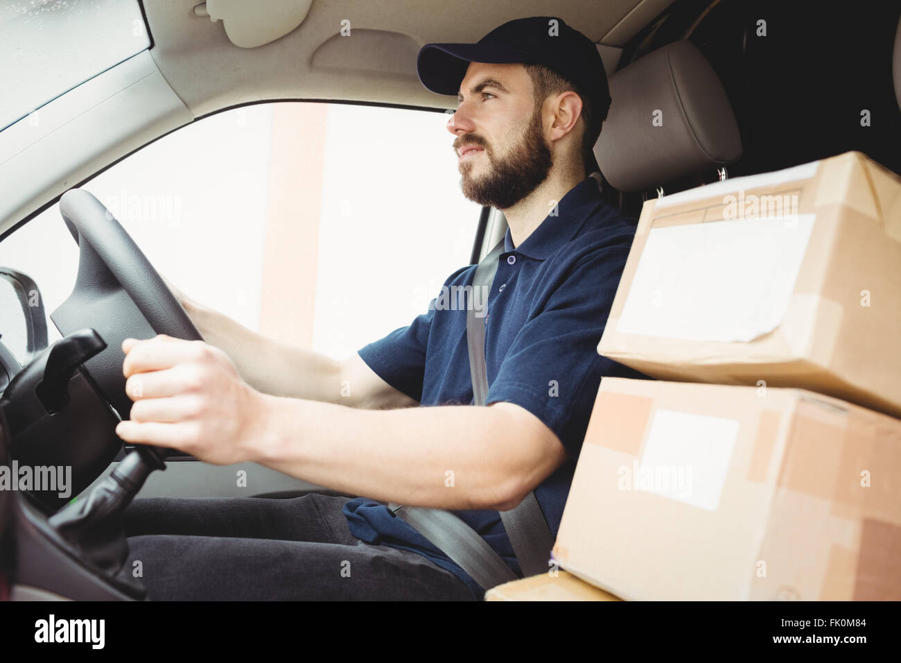 Delivery man driving his van Stock Photo - Alamy