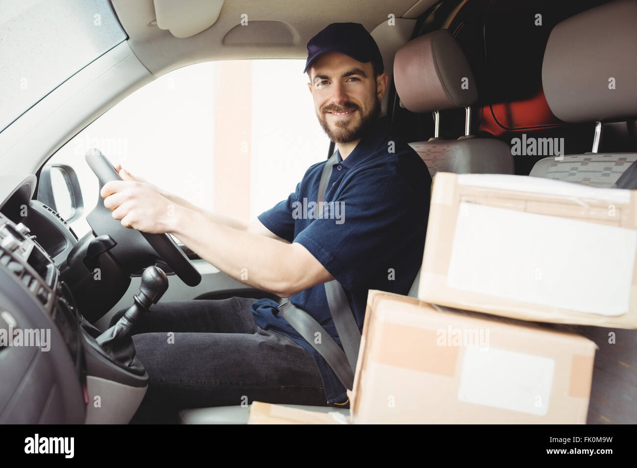 Delivery man driving his van Stock Photo - Alamy