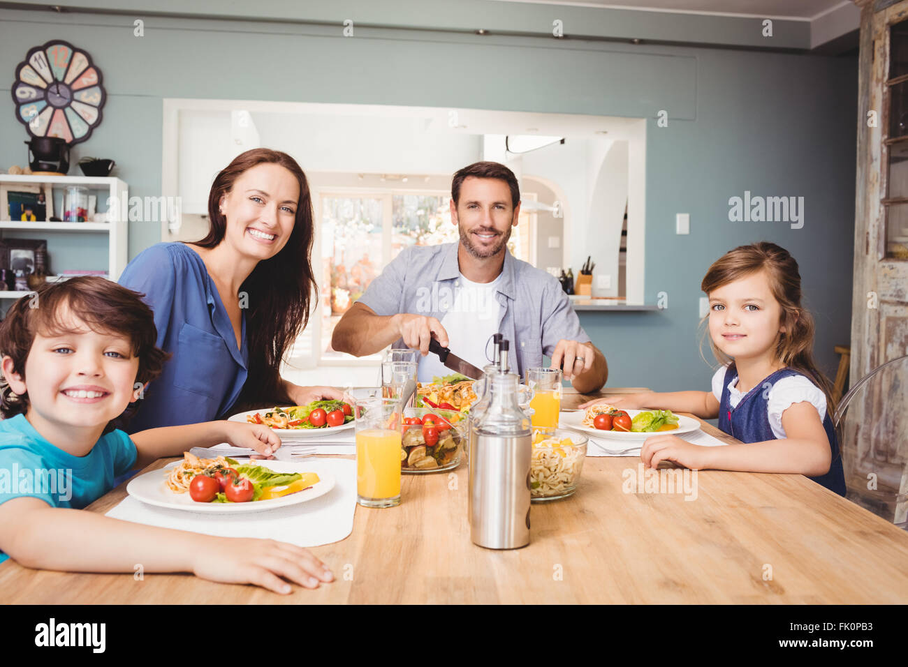 Portrait of happy family with food on dining table Stock Photo - Alamy