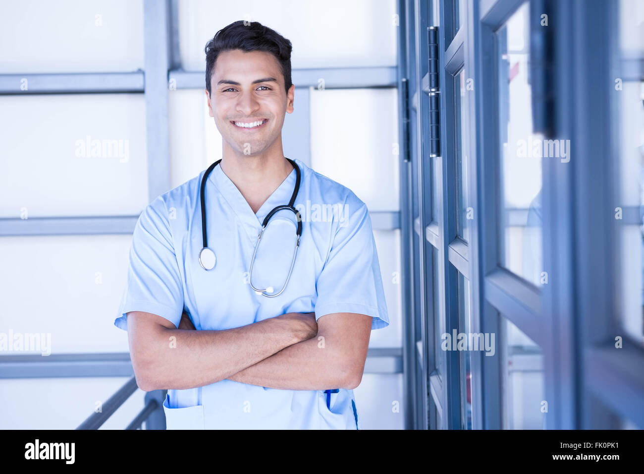 Happy male doctor standing with arms crossed Stock Photo - Alamy