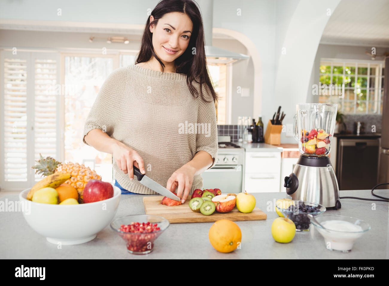 Portrait of happy woman cutting fruits Stock Photo - Alamy