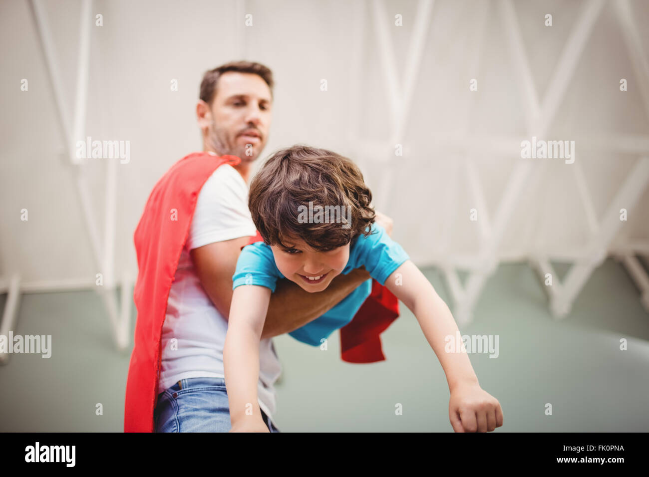 Low angle view of father holding son wearing superhero costume Stock ...