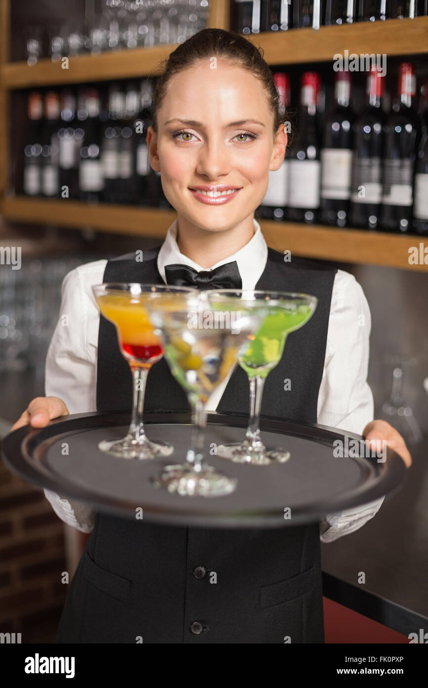 Barmaid holding plate with cocktails Stock Photo - Alamy
