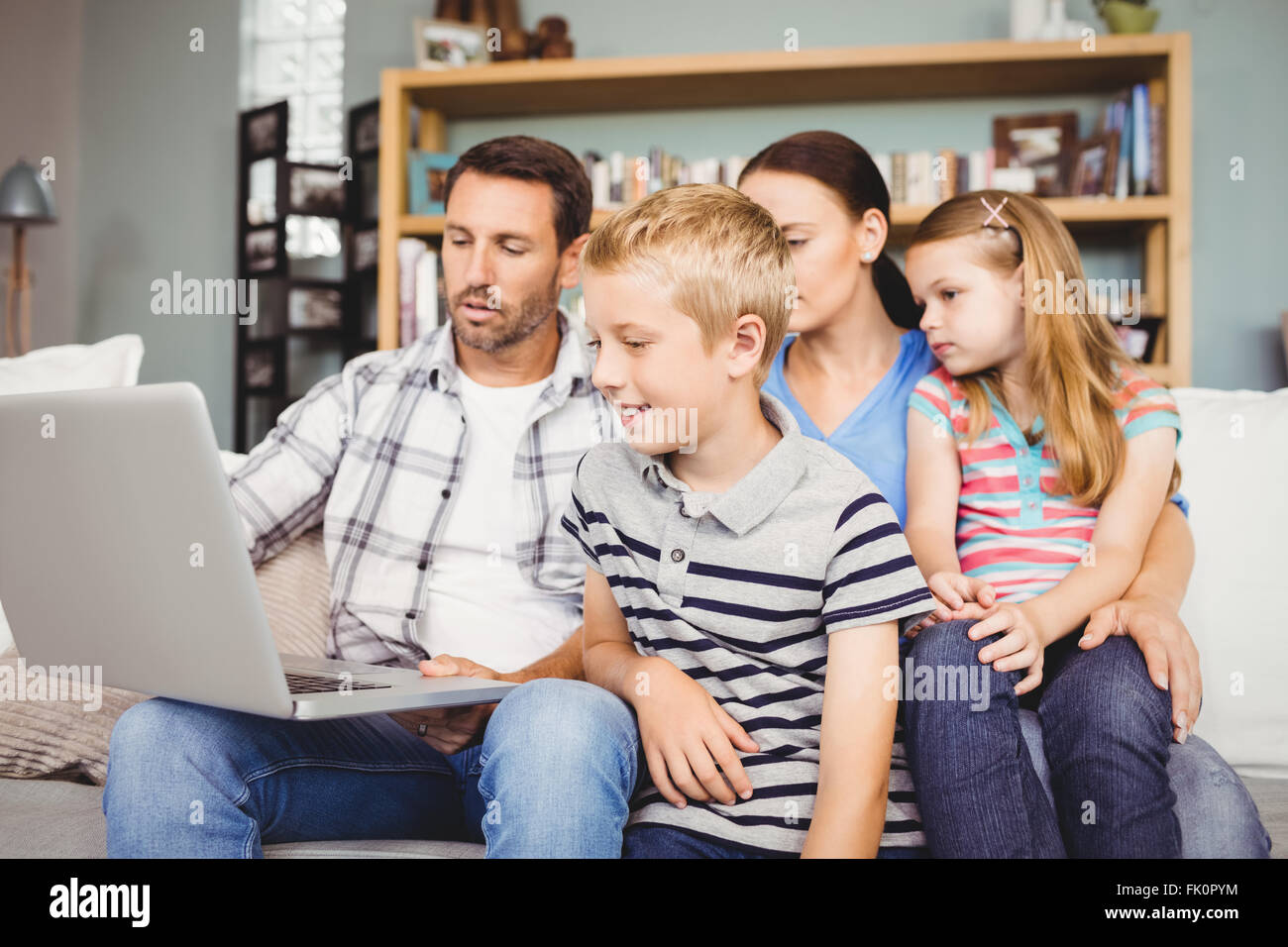 Family looking in laptop at home Stock Photo - Alamy