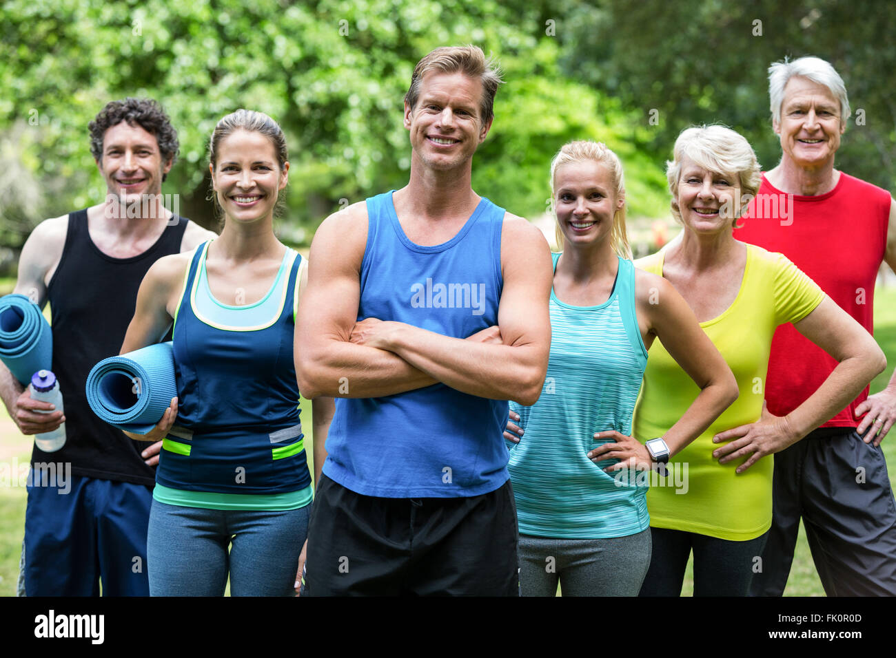 Fitness class posing with sports mats Stock Photo - Alamy