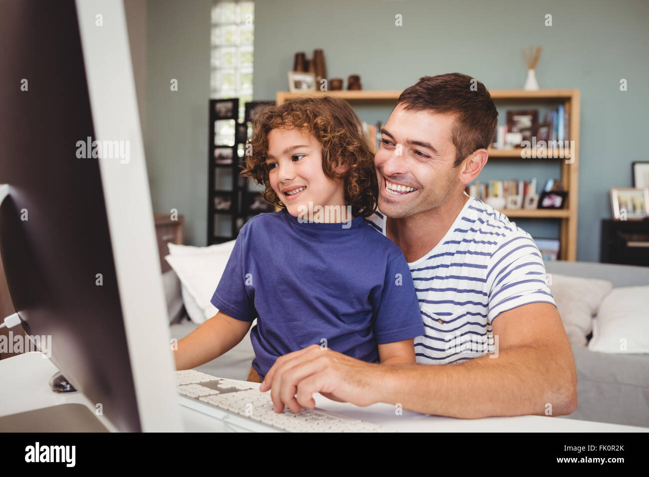 Happy father and son using computer at home Stock Photo - Alamy