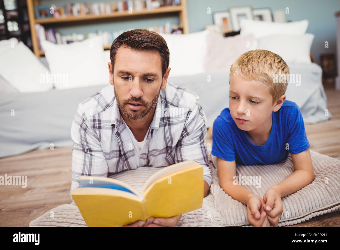 Close-up of father and son reading book at home Stock Photo - Alamy