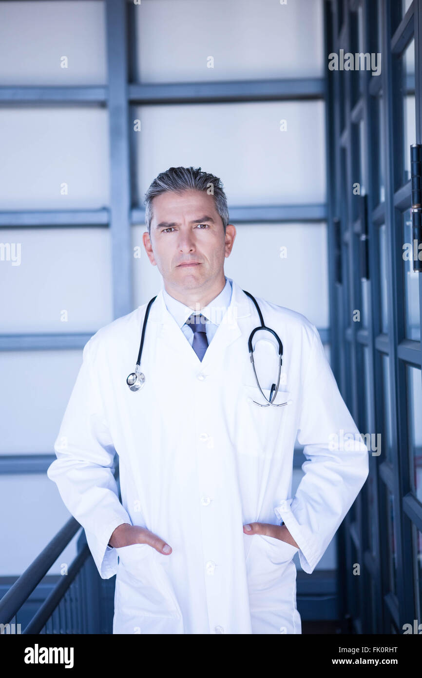 Serious male doctor standing with hands in pocket Stock Photo - Alamy