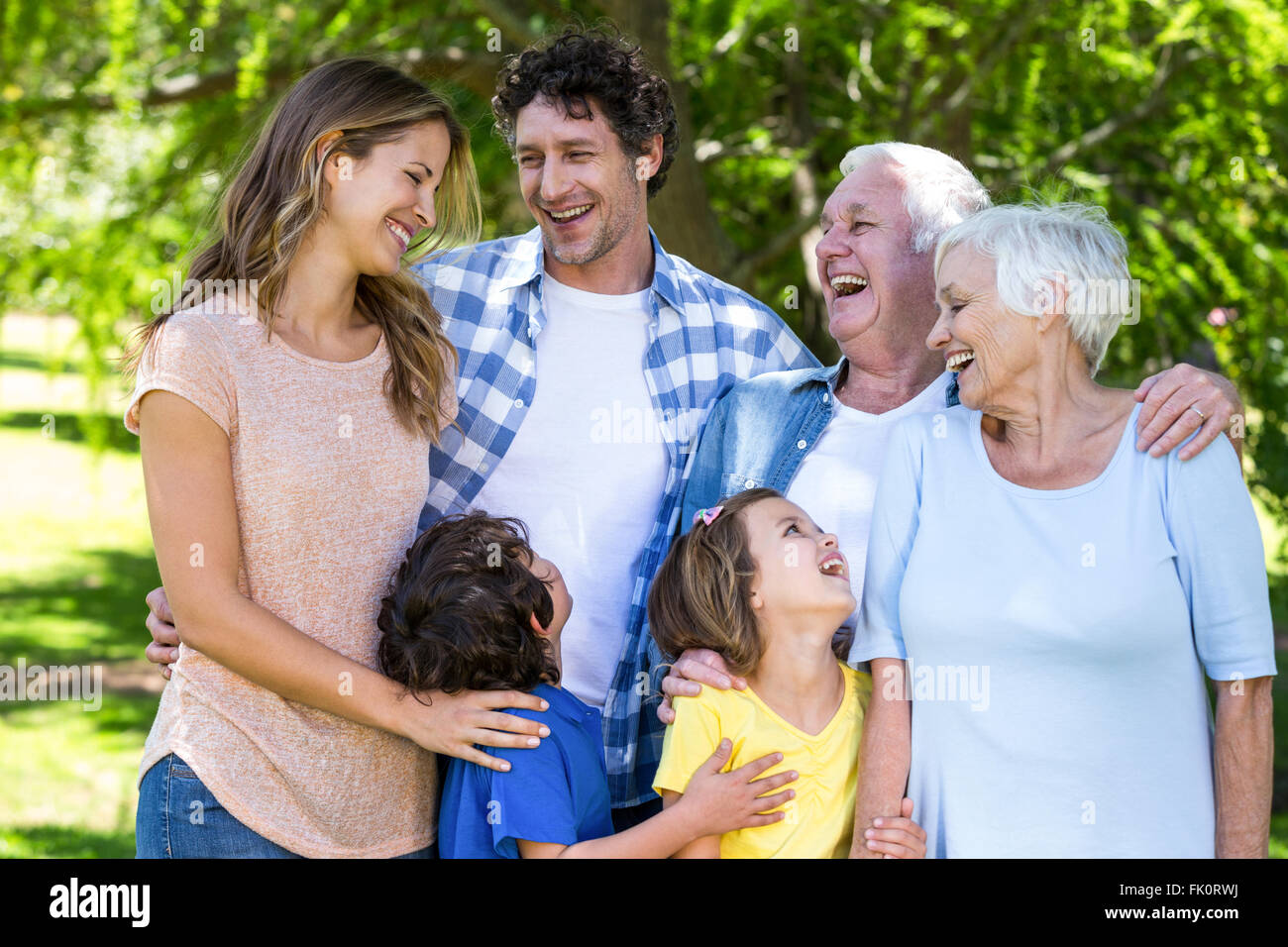Smiling family hugging Stock Photo - Alamy