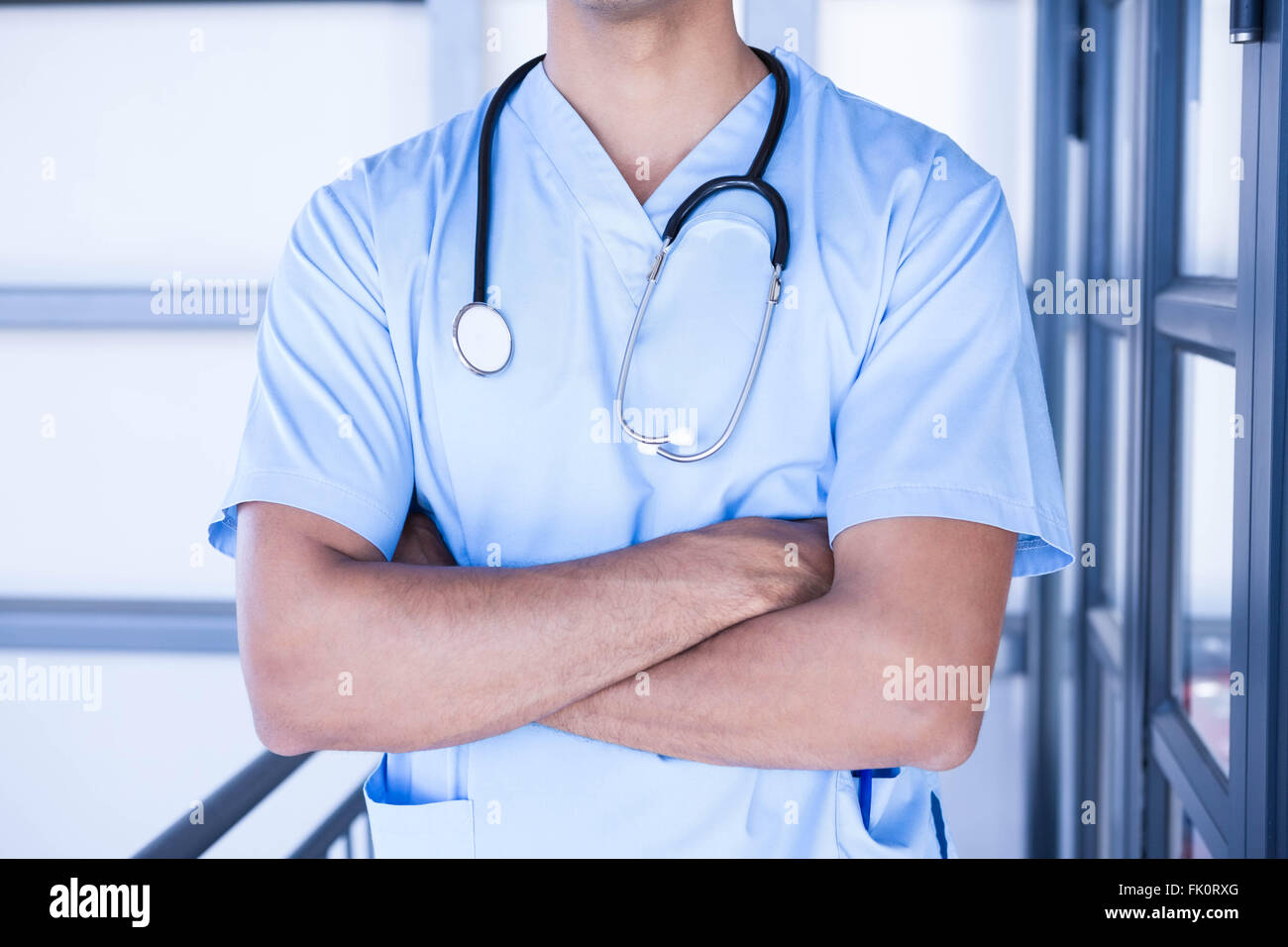 Male doctor standing with arms crossed Stock Photo - Alamy