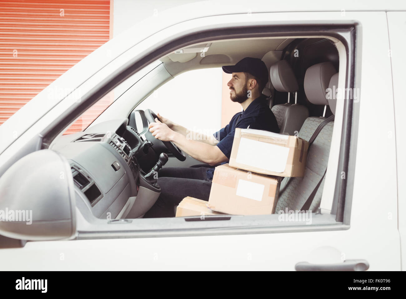 Delivery man driving his van Stock Photo - Alamy