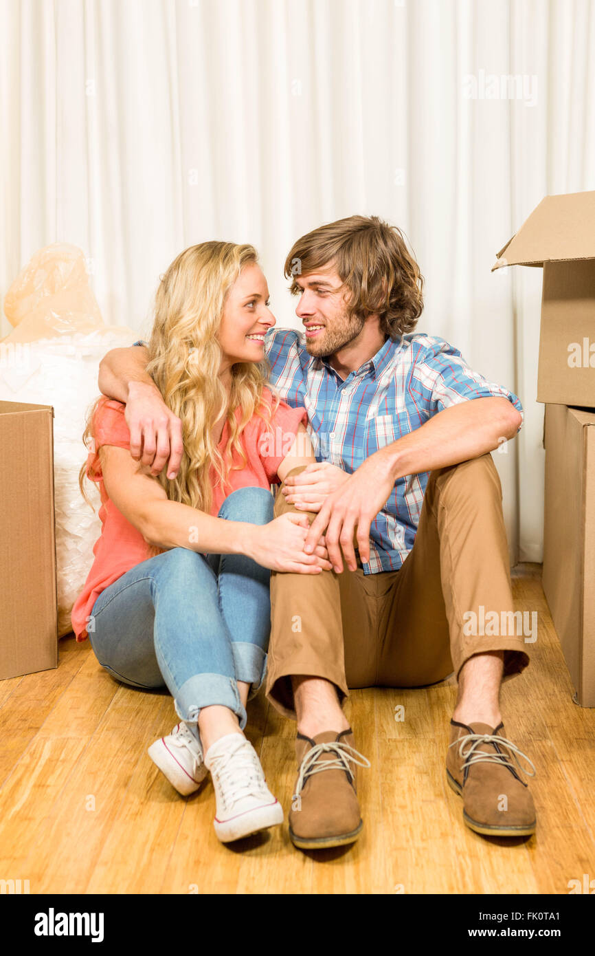 Happy couple sitting on the floor Stock Photo - Alamy