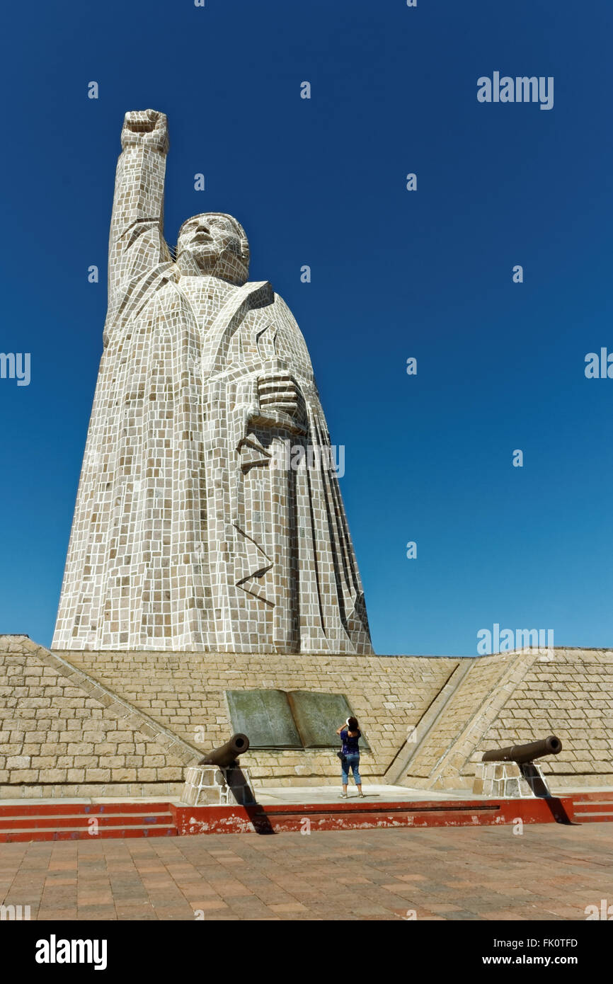 A woman photographing the statue of Jose Morelos on the island of ...