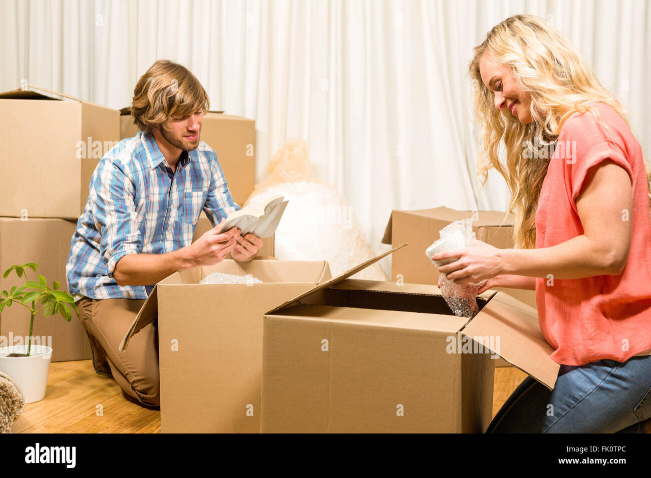 Happy couple unpacking after move Stock Photo - Alamy