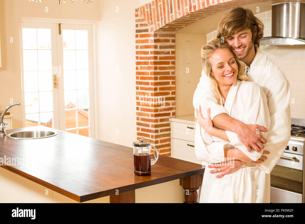 Cute couple cuddling in bathrobes Stock Photo - Alamy