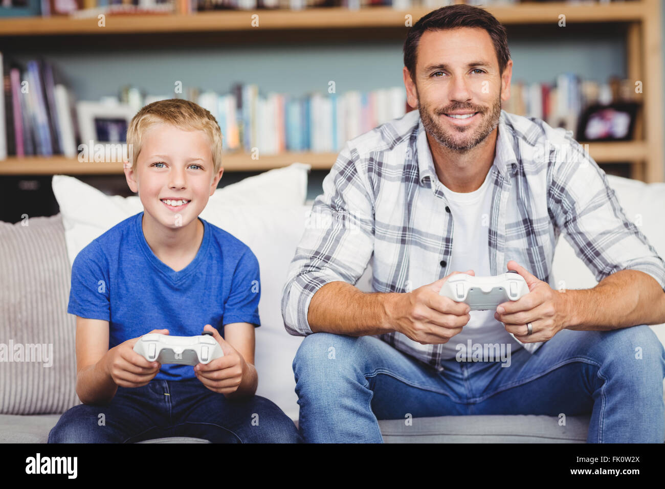 Portrait of smiling father and son playing video game Stock Photo - Alamy