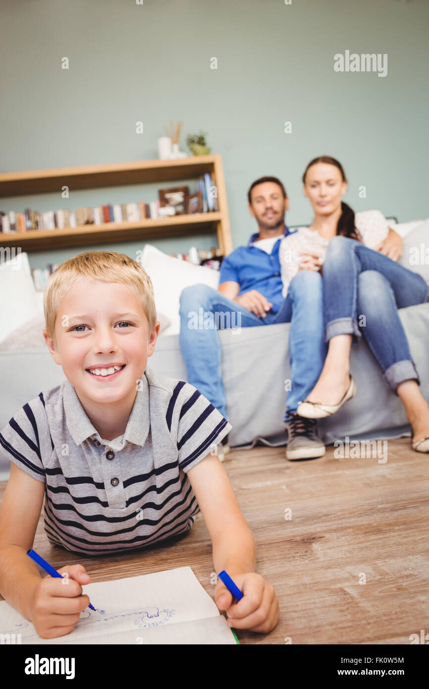 Portrait of happy boy drawing on book Stock Photo - Alamy