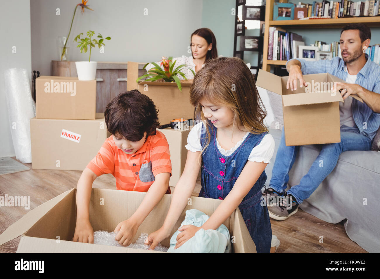 Family unpacking cardboard boxes Stock Photo - Alamy