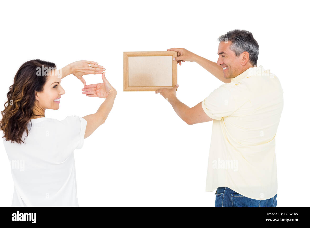 Happy couple holding picture frame Stock Photo - Alamy