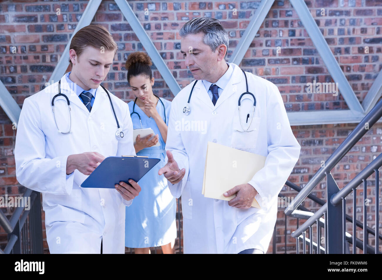 Doctors discussing medical report on staircase Stock Photo - Alamy