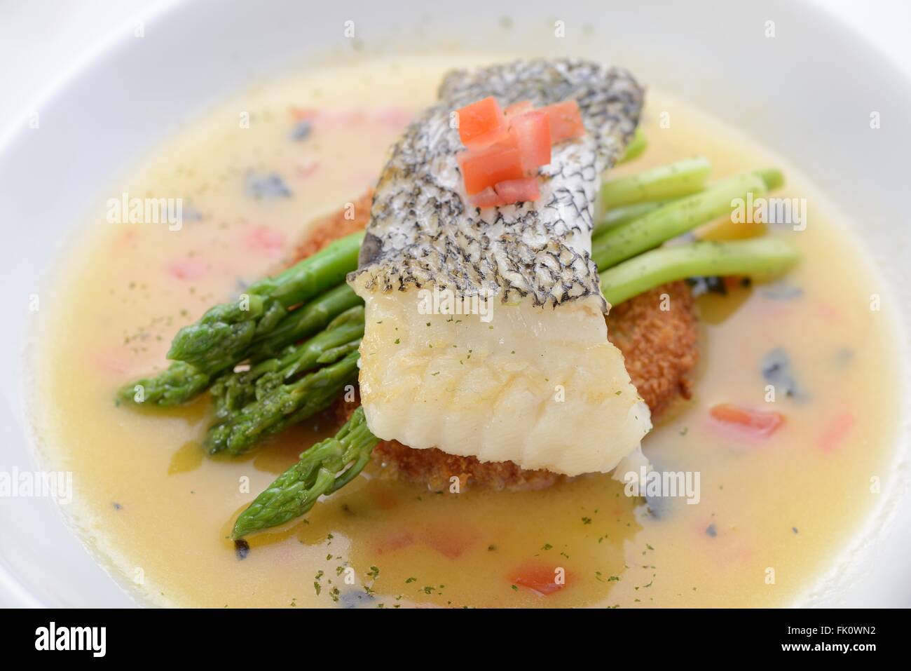 Braised cod fish on top of Asparagus Stock Photo - Alamy