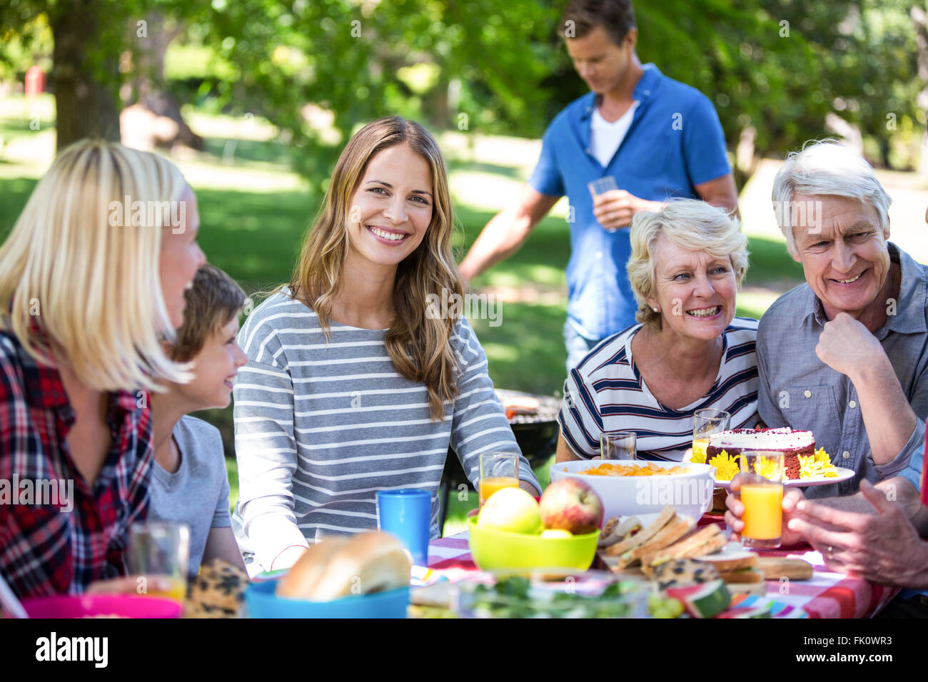 Family and friends having a picnic with barbecue Stock Photo - Alamy