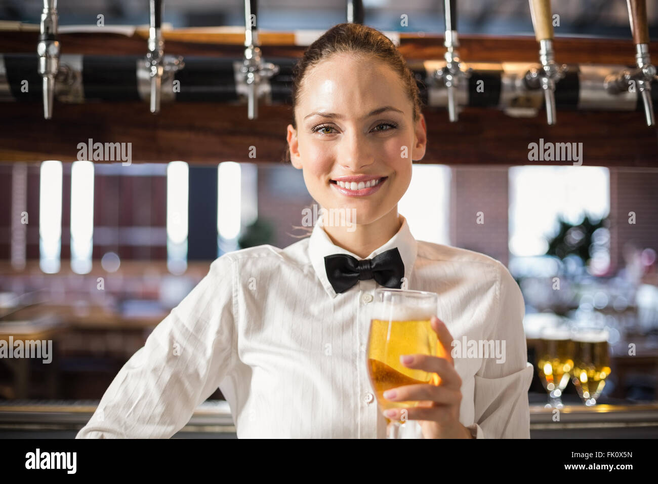 Barmaid holding a beer Stock Photo - Alamy