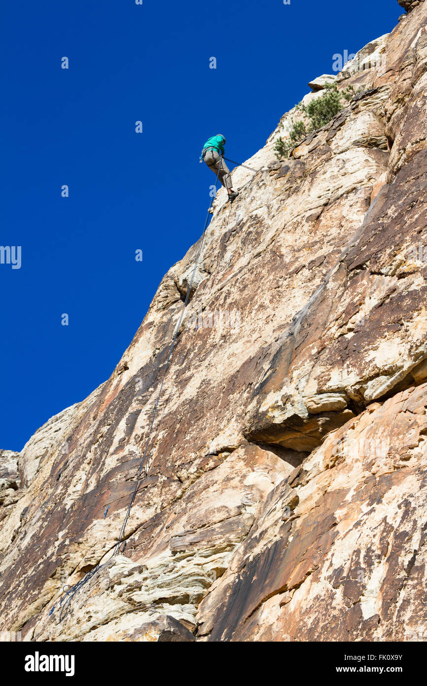 young man repelling down a sandstone cliff in youth western Utah Stock ...
